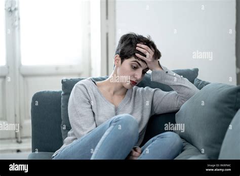 Portrait Of Beautiful Desperate And Depressed Young Woman On Sofa