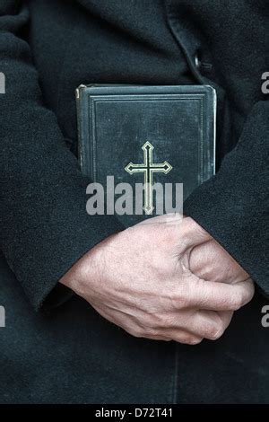 Close Up Of Pastor In Black Suit Holding Bible Book During Sermon In