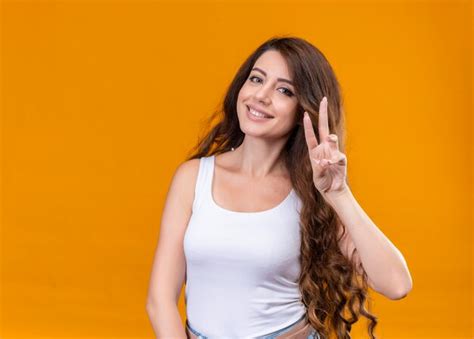 Linda Garota Sorridente Mostrando Dois Em Um Espaço Laranja Isolado Com