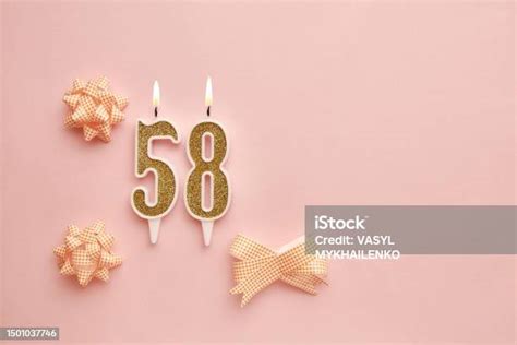 축제 장식이 있는 파스텔 핑크 배경에 숫자 58이 있는 양초 생일 축하 촛불 생일 기념일 중요한 날짜 휴일을 축하하는 개념입니다