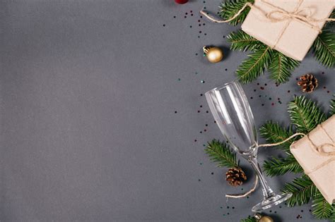 새해 복 많이 받으시고 전나무 나뭇 가지 안경 샴페인 소나무와 색종이 회색 배경에 공예 종이로 장식 된 수제 선물 상자와 크리스마스 플랫 레이 상단 보기 복사 공간 12월에