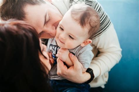 La Madre Y El Padre Abrazan A Su Hijo Foto Gratis