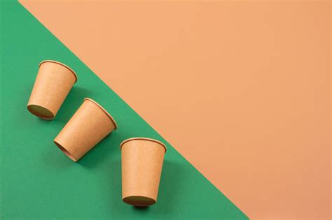 친환경 테이크아웃 음료 컵 세트 카피스페이스가 있는 녹색과 갈색 배경의 크래프트 페이퍼 커피 컵 재활용 크래프트 종이 식기 및