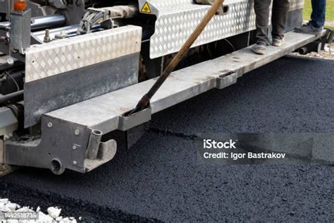 도 공사 중 아스팔트 포장 재료 기계를 운영 하 고 복구 작업자 작동 합니다 포장 재료 피니셔 아스팔트 피니셔 또는 포장 기계는 아스팔트의 레이어를 배치 합니다 싫지만 도로