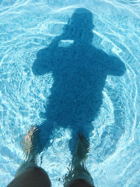 Premium Photo Low Section Of Man With Shadow On Swimming Pool