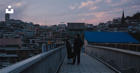 도시 위의 다리 위를 걷는 남자와 여자 사진 Unsplash의 무료 용산구 이미지