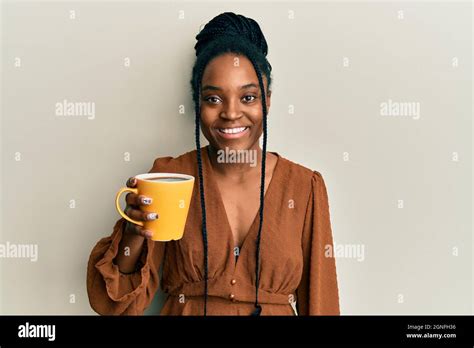 African American Woman With Braided Hair Drinking A Cup Coffee Looking