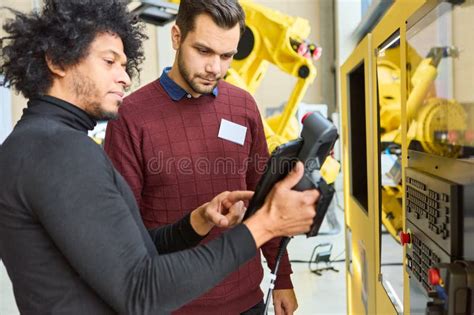 Engineers Programming Industrial Robot With Control Panel For Precision Automation In