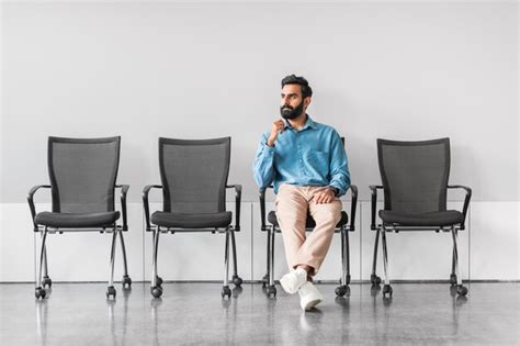 Premium Photo Pensive Indian Man In Office With Empty Chairs