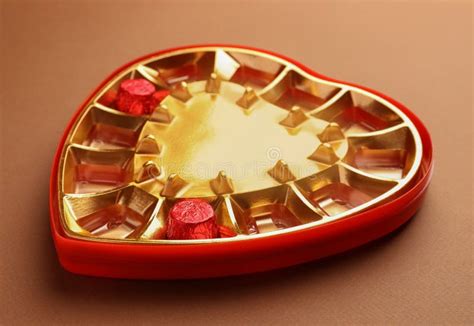 Partially Empty Heart Shaped Box Of Chocolate Candies On Brown