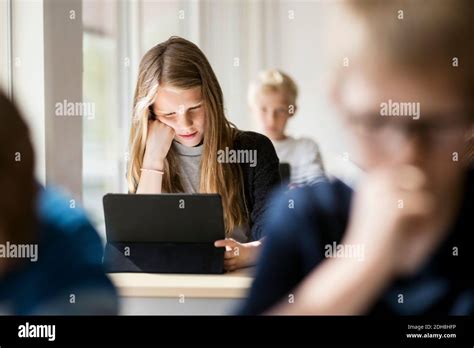Girl Reading From Digital Tablet For Learning In Classroom Stock Photo Alamy