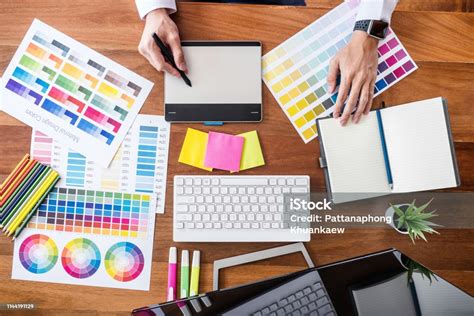 색상 선택에 작업 하 고 작업 도구 및 액세서리와 직장에서 그래픽 태블릿에 그리기 남성 창조적 인 그래픽 디자이너의 이미지