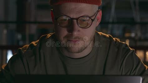 The Hacker Looks Up From The Display At The Camera With An Angry Look