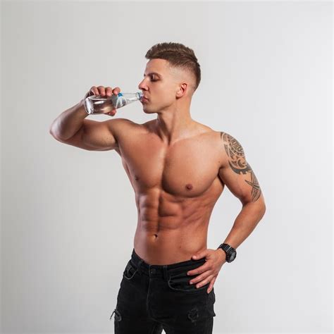 Premium Photo Handsome Sports Fitness Guy With A Muscular Body Drinks