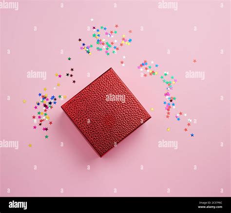 Square Red Shiny Box And Multicolored Sparkles On A Pink Background