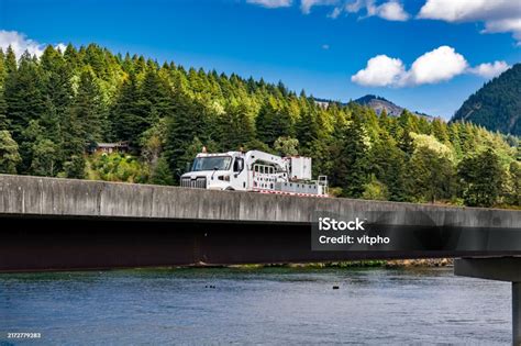 유틸리티 기술 유지 보수 리프팅 크래들 및 컬럼비아 강의 지류를 가로 지르는 다리에서 달리는 다른 장비가있는 흰색 대형 장비 세미 트럭 0명에 대한 스톡 사진 및 기타