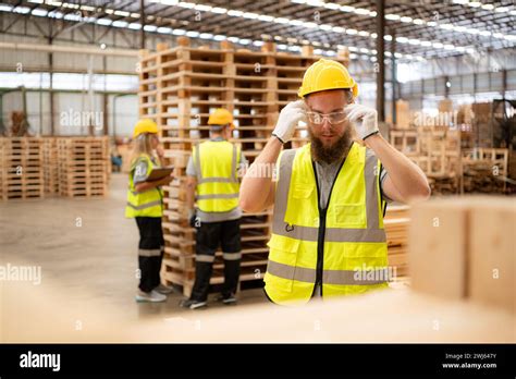 Young Workers Working In A Woodworking Factory Using A Hammer To Work