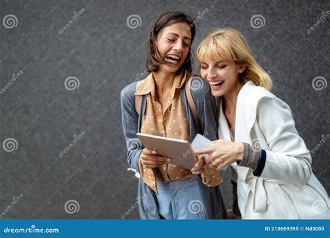 Smiling Young Lesbian Girls Having Fun With Tablet Outdoor Stock Image
