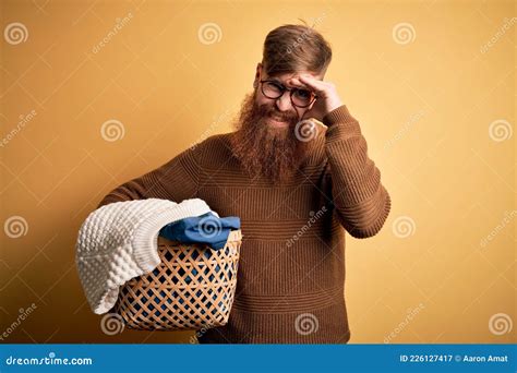 Redhead Irish Man With Beard Doing Housework Laundry Over Yellow