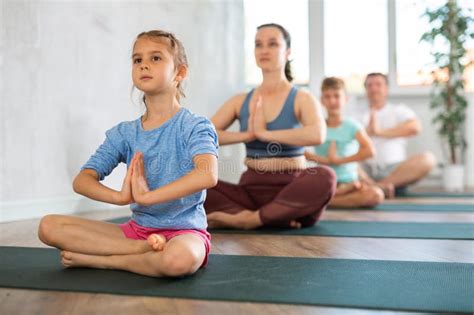 Confident Mom Dad Son And Daughter Sit In Padmasana And Greet