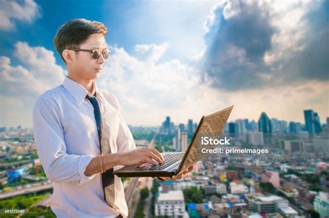 노트북 및 디지털 태블릿 도시 배경 사용 하 여 하는 젊은 사업가 경제에 대한 스톡 사진 및 기타 이미지 경제 고층 건물