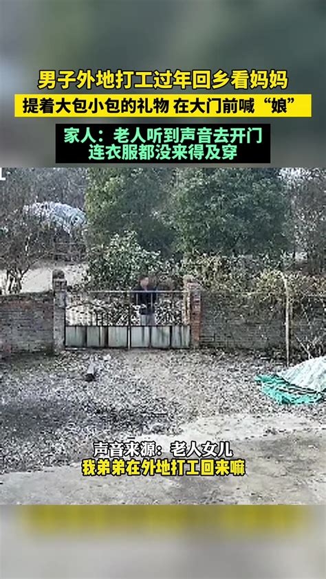 男子外地打工过年回乡看妈妈，提着大包小包的礼物 在大门前喊“娘”