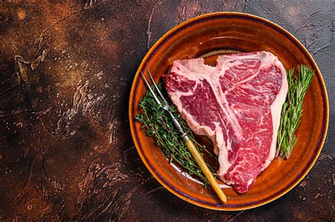 접시에 허브와 원시 T 뼈 쇠고기 고기 스테이크 어두운 배경 맨 위 보기입니다 복사 공간 0명에 대한 스톡 사진 및 기타 이미지 Istock