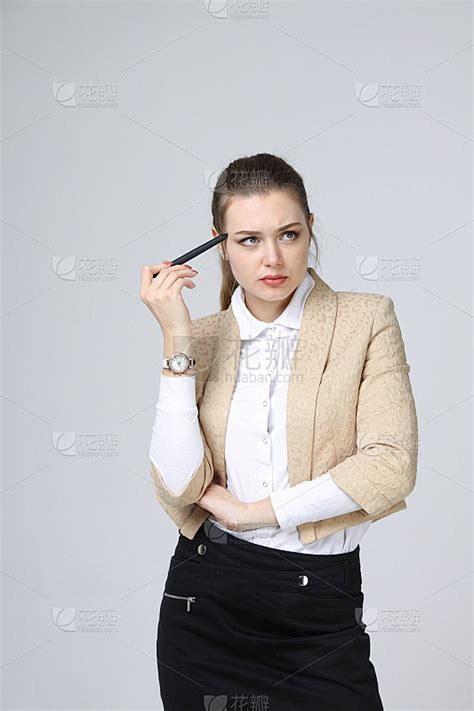 年轻的女商人手里拿着笔，思考着