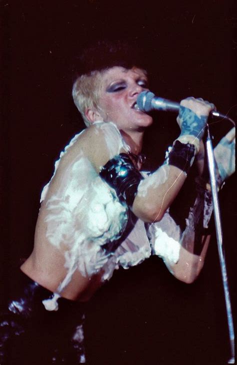 A Man In Costume Holding A Microphone And Singing Into It S Mouth While Standing On Stage