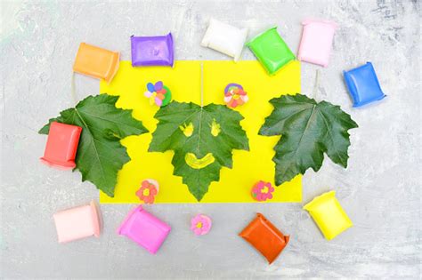 아이는 종이와 천연 잎에서 플라스틱과 카드로 꽃을 만들었습니다 환경 보호 생태 개념 미술 학습 및 교육의 개념 0명에 대한 스톡
