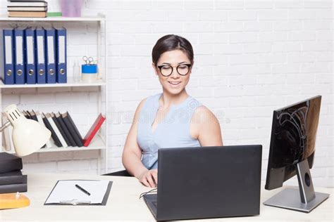 Девушка дела сидит в офисе за столом с компьютером Стоковое Изображение