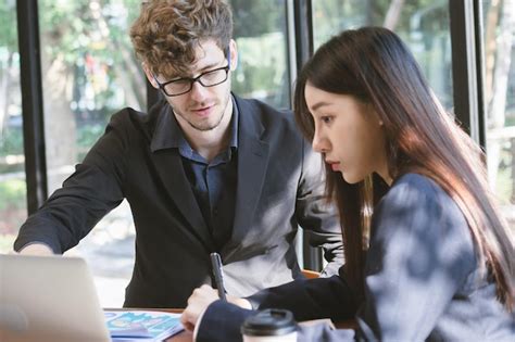 비즈니스 전문가 그룹 젊은 아시아인 백인 작업 및 의사 소통 데이터 분석 토론 랩톱 컴퓨터 사용 팀은 직장 동료와 함께 새로운 프로젝트에 대해 설명합니다