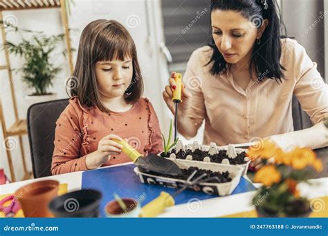 Ni A Ayuda A Su Madre A Cuidar De Las Plantas Foto De Archivo Imagen De Hija Papel
