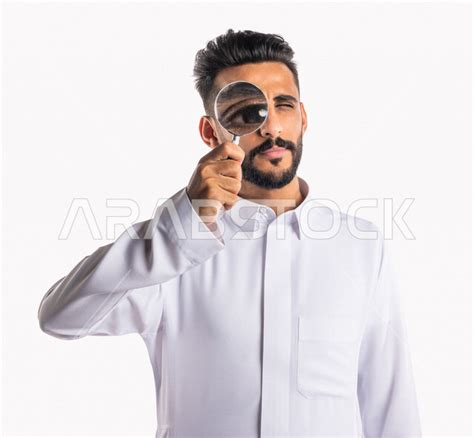بورتريه بصورة مقربة لرجل عربي خليجي سعودي ، ينظر من خلال العدسة المكبرة