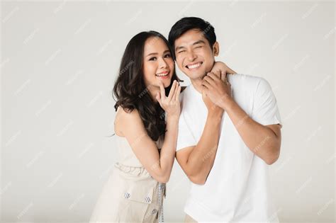 젊은 매력적인 아시아 커플 흰색 티셔츠와 베이지색 바지를 입은 남자 베이지색 드레스를 입은 여자 서로 놀리는 사전 결혼식