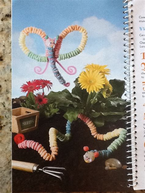 A Spiral Notebook With An Image Of A Butterfly And Flowers On It Next