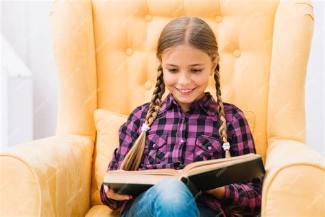 Милая маленькая девочка читает книгу Бесплатно Фото