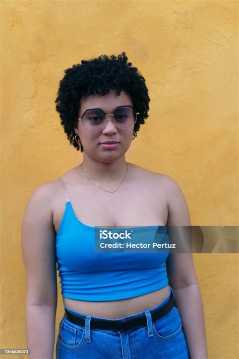 Wanita Dengan Gaya Rambut Afro Dan Kacamata Hitam Melihat Serius Ke