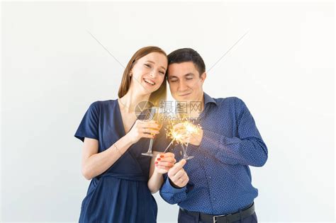 以孟加拉灯光和香槟杯庆祝圣诞节或新年夜晚会的男女近身高清图片下载 正版图片506276564 摄图网