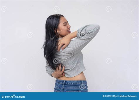 A Young Asian Woman Struggles To Reach Her Back A Futile Attempt To