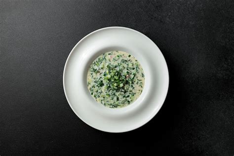 신선한 오이 소시지 육수 사워 크림을 곁들인 차가운 수프가 검은색 배경에 접시 모자에 담겨 있습니다 전통 요리는 Okroshka입니다 건강한 생활방식에 대한 스톡 사진 및