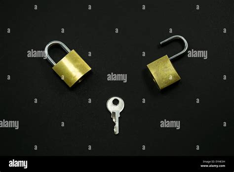 Two Small Locks And A Key Against A Black Background Conceptual Image About Problem Solving
