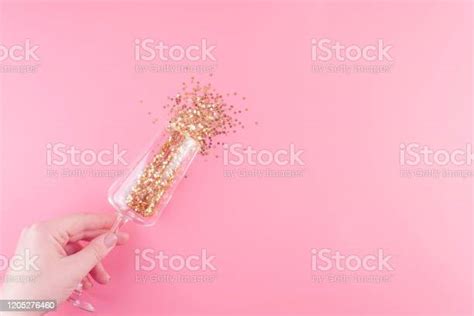 여성의 손은 분홍색 파스텔 배경에 금색 별 색종이로 가득 샴페인 한 잔을 보유하고 있습니다 0명에 대한 스톡 사진 및 기타