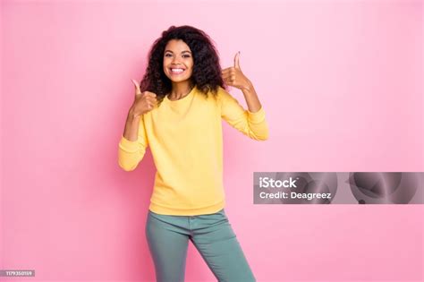 초상화 의 긍정적 인 쾌활한 아프리카 소녀 표시 엄지 손가락 최대 추천 피드백 광고 착용 노란색 점퍼 바지 위에 고립 된 핑크 컬러 배경 갈색에 대한 스톡 사진 및 기타