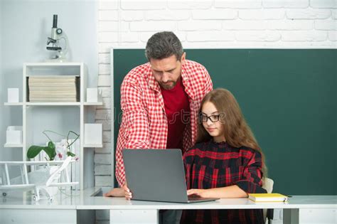elementary school teacher and pupil doing homework using computer