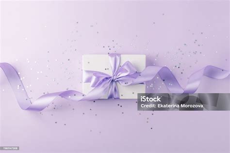 질감의 활과 깃털로 장식된 라일락 배경의 공예 기프트 박스는 로맨틱한 럭셔리 분위기를 연출합니다 생일 기념일 선물 기프트 엽서에