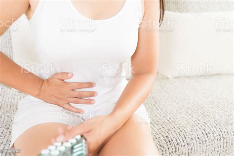 고통 복 통 집에서 소파에 앉아 있는 젊은 여자 만성 위 염입니다 복 부 Bloating 개념입니다 여자에 대한 스톡 사진 및