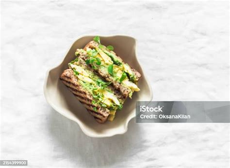 맛있는 아침 식사 브런치 스낵 밝은 배경에 아보카도 스크램블 에그 마이크로그린을 곁들인 통곡물 샌드위치 평면도 새싹채소에 대한