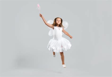 밝은 배경에 날개와 마술 지팡이가있는 요정 의상을 입은 귀여운 소녀 날개달린 의상에 대한 스톡 사진 및 기타 이미지 날개달린