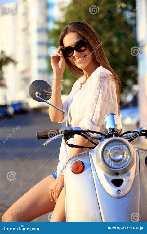 Portrait Of A Beautiful Girl Sitting On Silver Retro Scooter Smiling